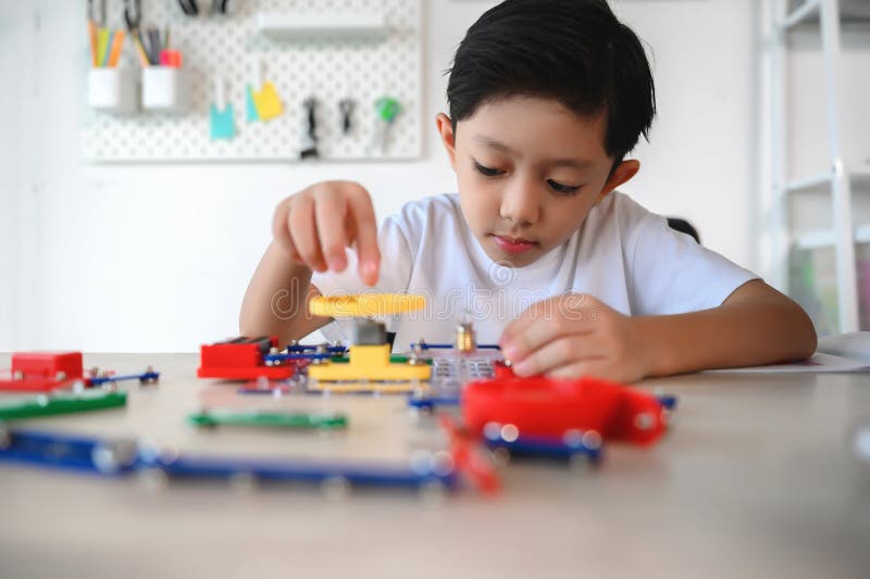 Asian Young Child Concentrate and Focus on Connecting Electronic ...