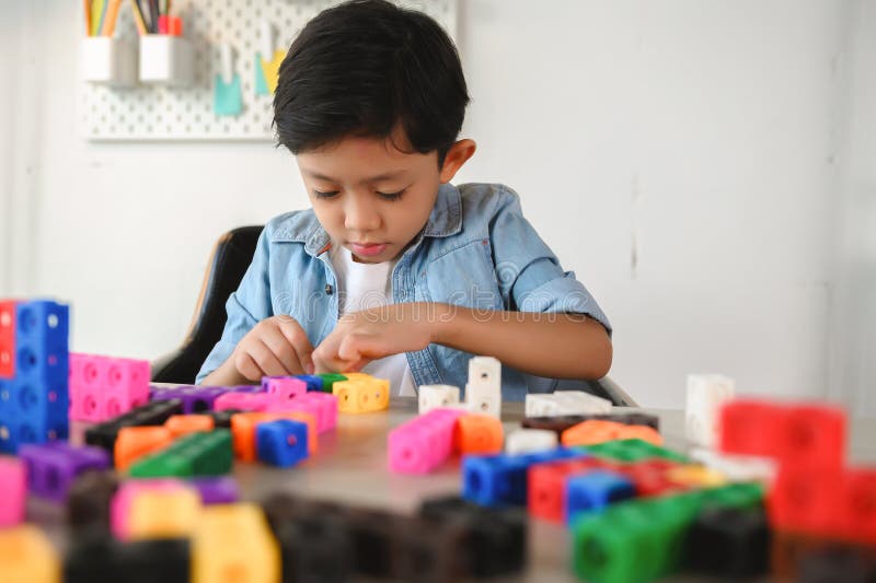 Asian Young Child Playing Colorful Plastic Cubes on Desk at Home ...