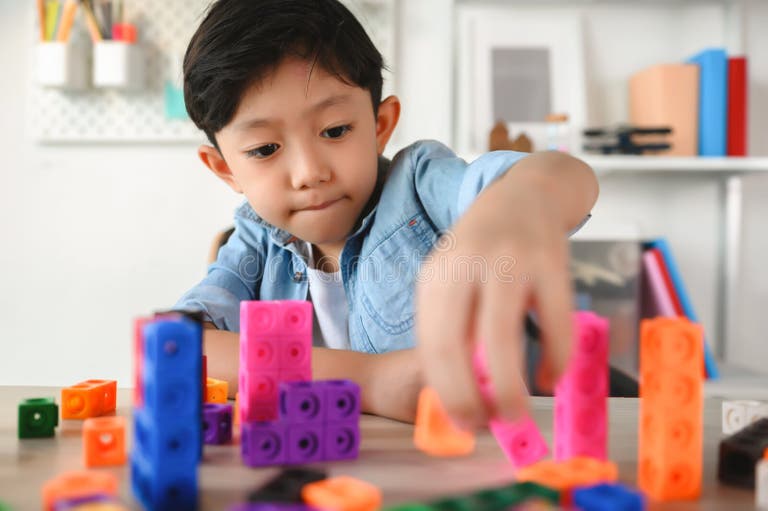 Asian Young Child Playing Colorful Plastic Cubes on Desk at Home ...