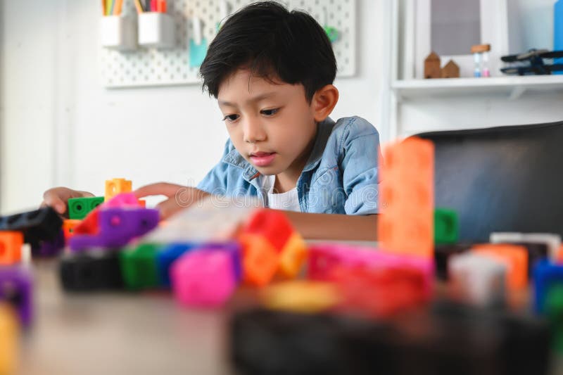 Asian Young Child Playing Colorful Plastic Cubes on Desk at Home ...