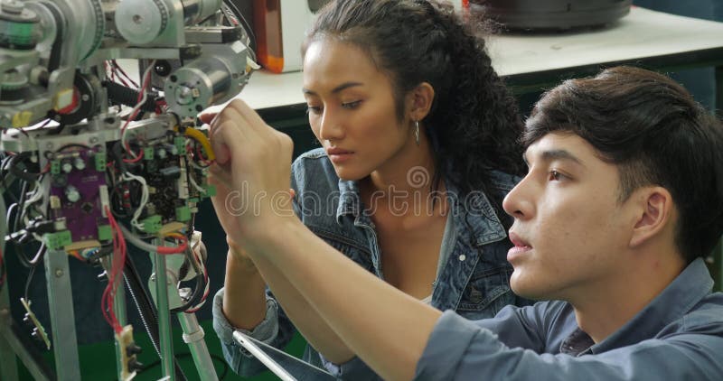 Young Electronics Engineer Team Collaborating on Construction of Robot ...