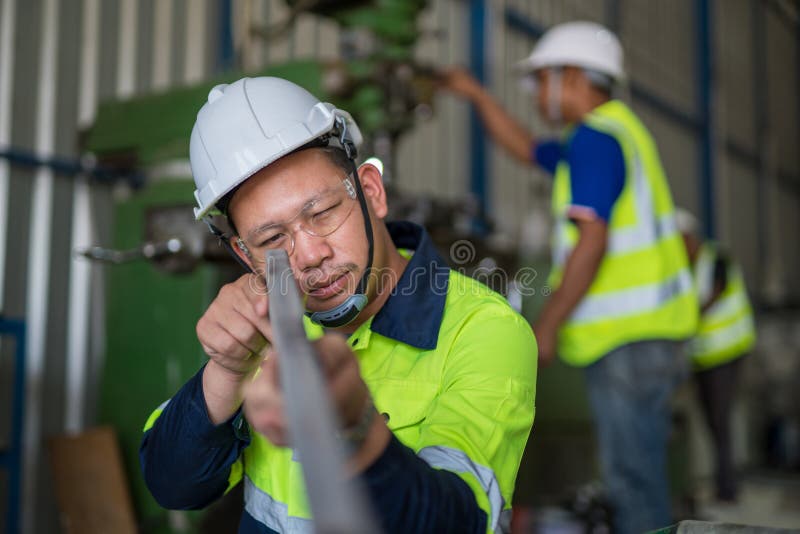 Asian Young Engineer Inspecting Workpieces in Industrial Factory with ...