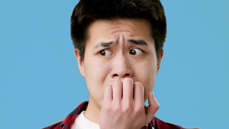 Young Man Looking Worried with a Concerned Expression Against a Blue ...