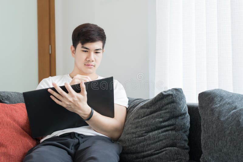 Asian Young Man Thinking and Wondering while Writing a Paper at Stock ...