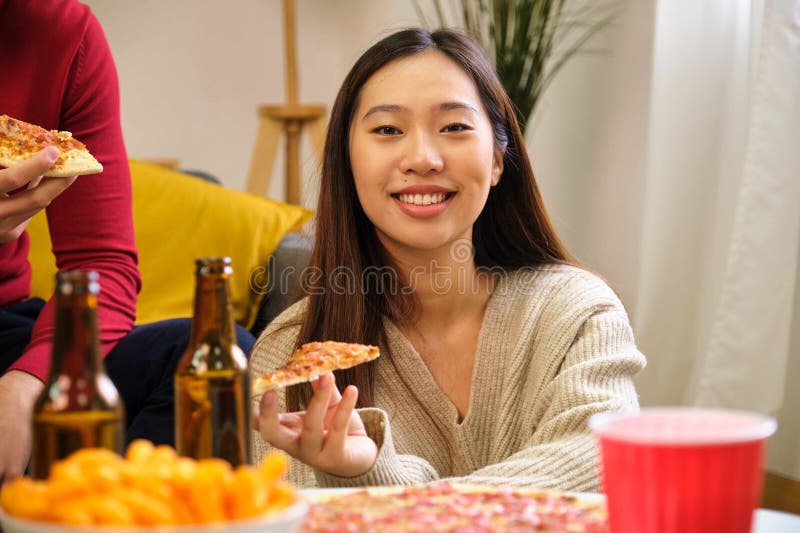Asian Young Woman Eating Pizza, Smiling and Looking at Camera at Home ...