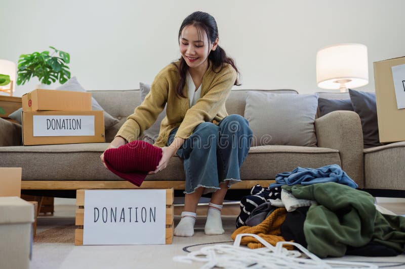 Asian Young Woman Packing Clothes at Home, Putting on Stuff into Donate ...