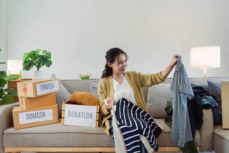 Asian Young Woman Packing Clothes at Home, Putting on Stuff into Donate ...