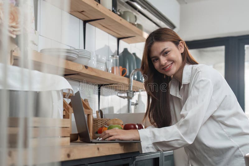 Asian Young Woman Use Laptop in the Kitchen at Home Stock Image - Image ...
