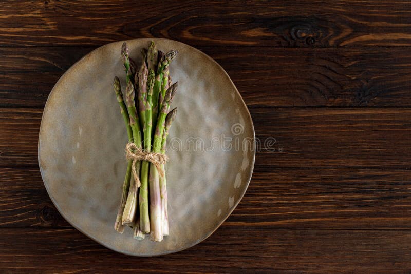 Asparagus Tied Bundle on Brown Plate on Rustic Table. Top View Stock ...