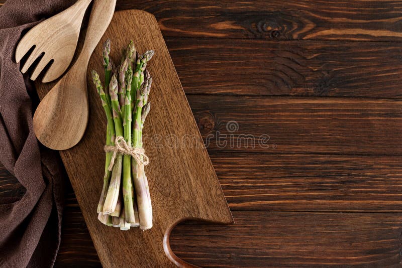 Asparagus Tied Bundle and Wooden Utensils on Rustic Table. Top View ...