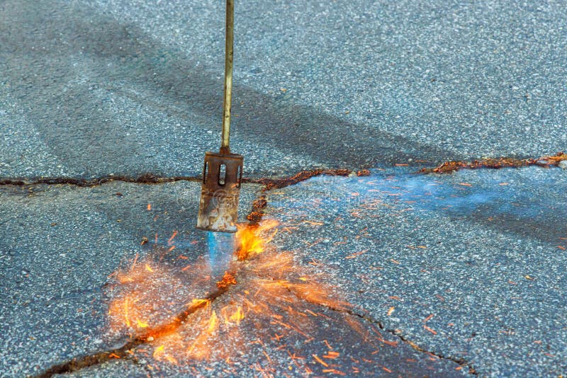 An Asphalt Patcher Performs Restoration Work in Cracks of Road Surface ...