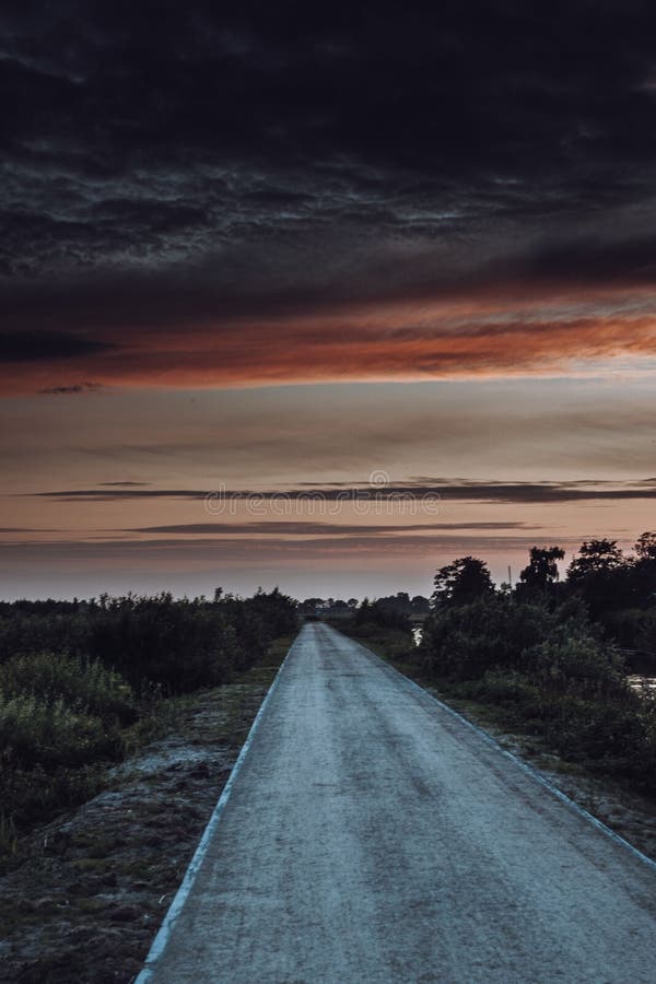 Asphalt Road Along the River during the Orange Sunset with Cloudy ...
