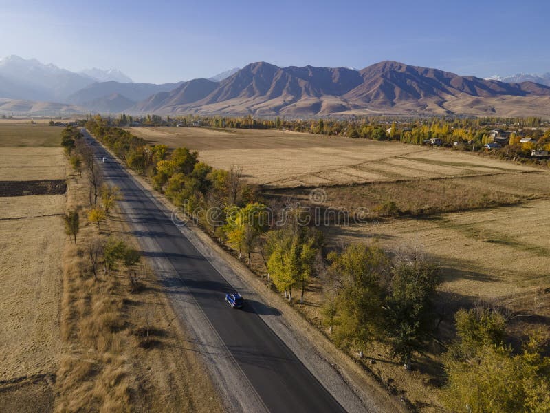 Asphalt Road and Car on High Mountains Background. Aerial View Stock ...