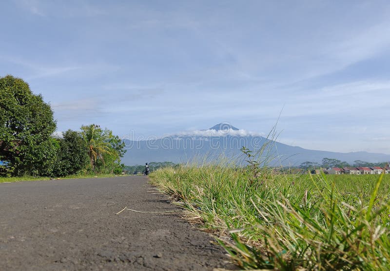 Asphalt Road and Grass with Mount Slamet and Clear Sky Stock Image ...
