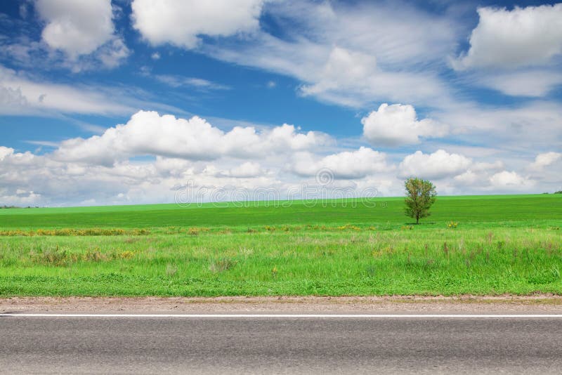 Asphalt Road, Green Grass Field and Sky with Clouds Stock Image - Image ...