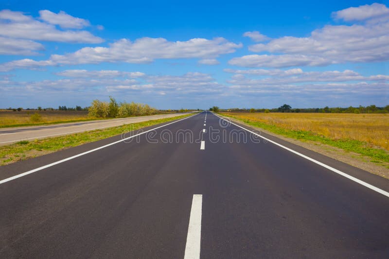 Asphalt Road among Green Plain Under a Blue Cloudy Sky Stock Image ...