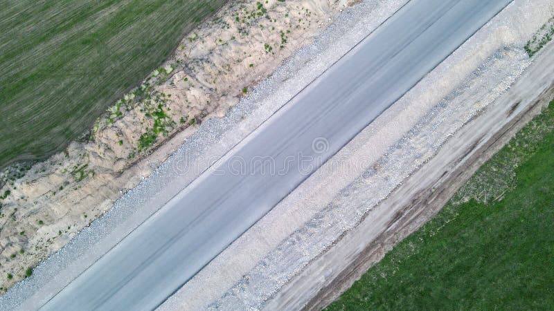 Asphalt Road Under Construction between Two Green Fields Stock Image ...
