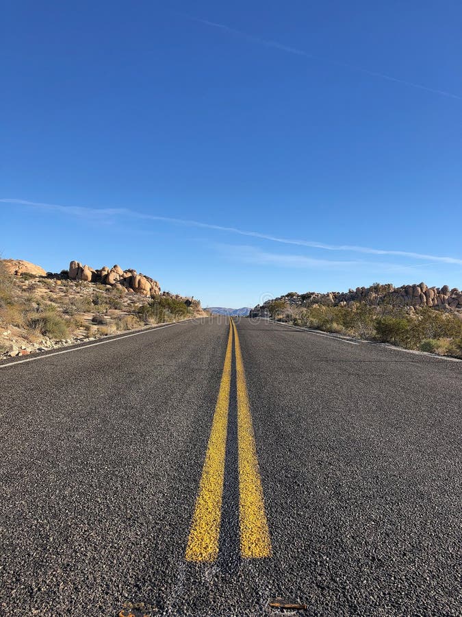 Asphalt Road with Yellow Lines Under a Clear Blue Sky Stock Photo ...