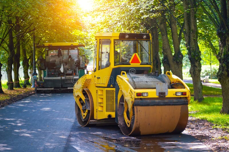Asphalt Roller Working on Pavement of a Road in the City Park among the ...