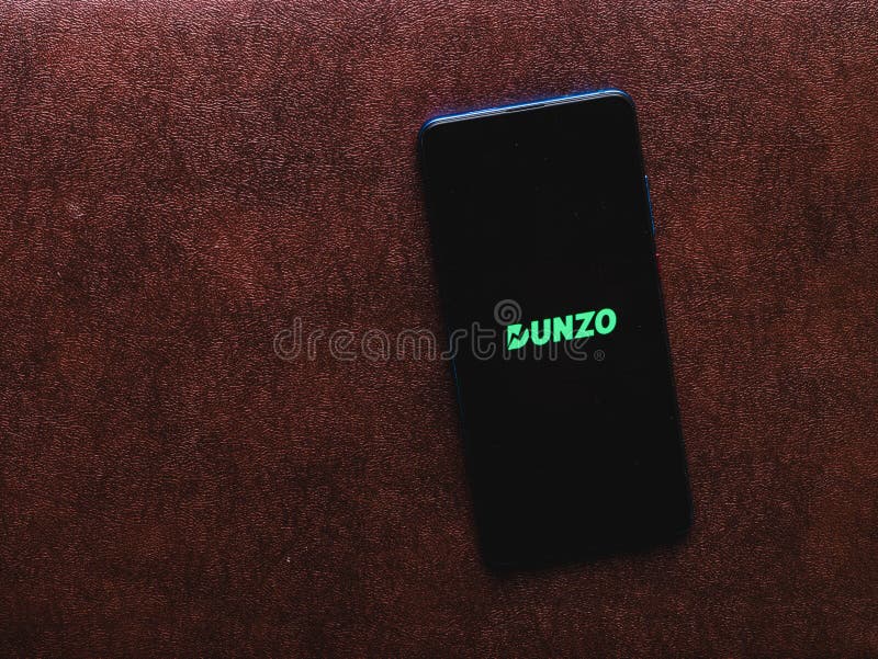 Dunzo Delivery App Logo Glowing on the Screen in a Dark Room and Finger ...