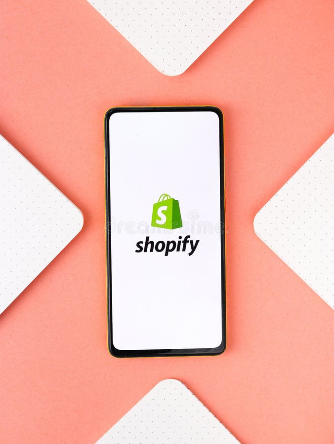 Phone with Shopify Icon on Screen Close Up with Blur Website on Laptop ...