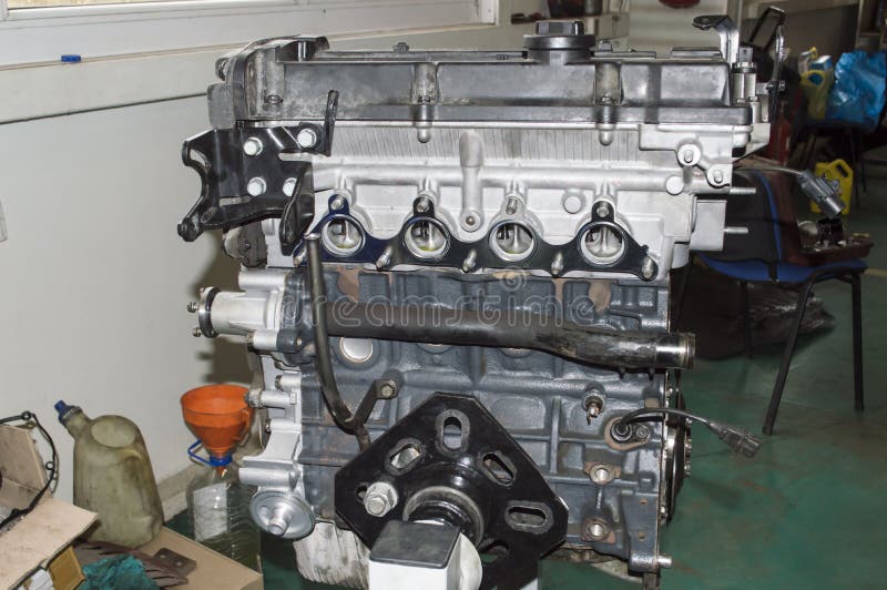 The Assembled Four-cylinder Car Engine is Installed on the Engine ...