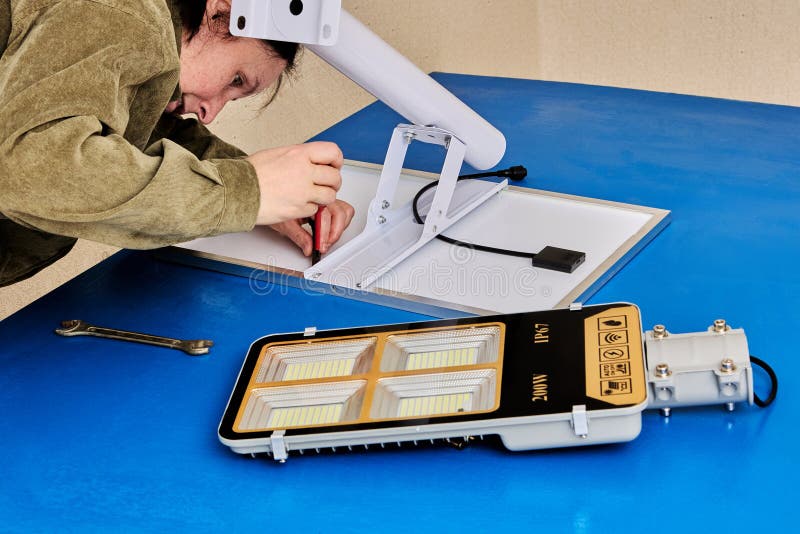 Assembling Stand Alone Solar Street Light, an Electrician Attaches ...