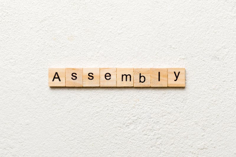 ASSEMBLY Word Written on Wood Block. ASSEMBLY Text on Cement Table for ...
