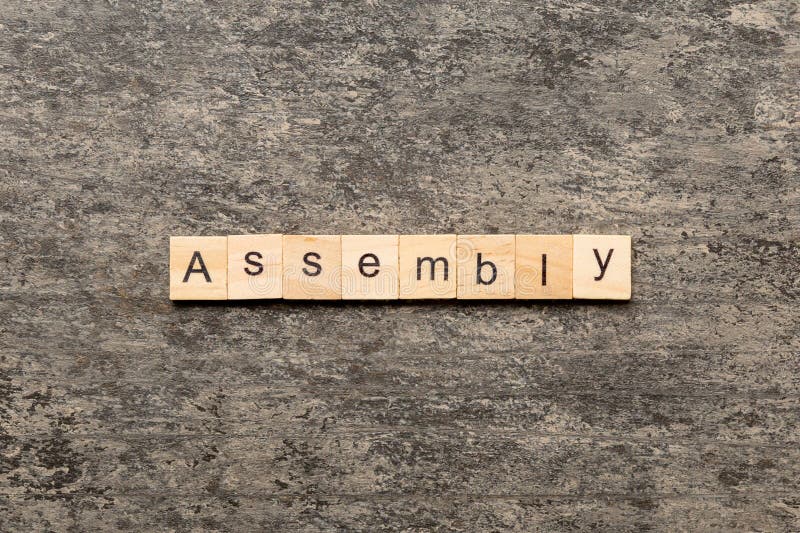 ASSEMBLY Word Written on Wood Block. ASSEMBLY Text on Cement Table for ...