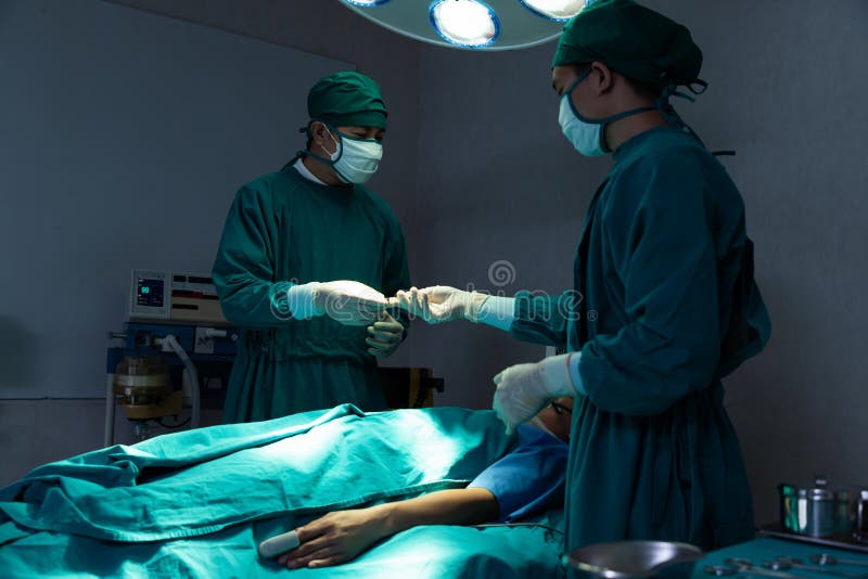 Assistant Hands Out Instruments To Surgeons during Operation Stock ...