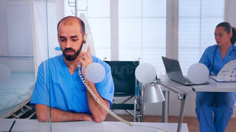 Assistant Talking at Phone, Checking Appointment Sitting Behind a Glass ...