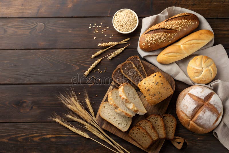 Assorted Breads Displayed on a Wooden Table with Grains and Wheat Stock ...