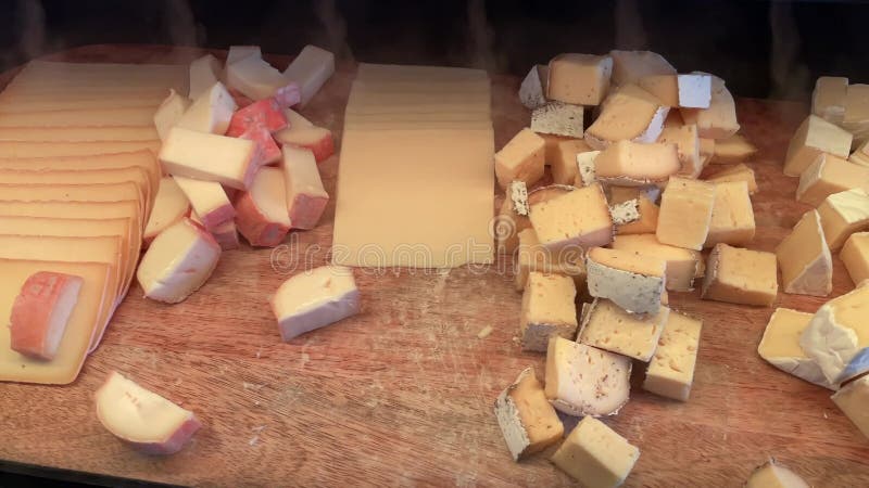Assorted Cheeses Cut into Cubes on Table with a Refrigeration System in ...