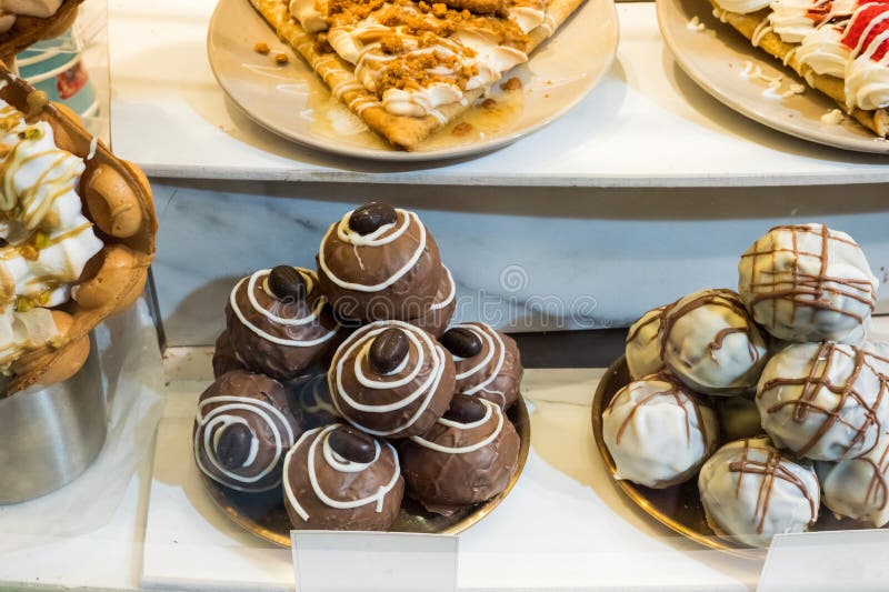 Assorted Chocolate and Vanilla Pastries with Cream Toppings on Display ...