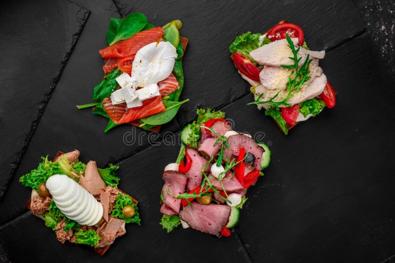 Assorted Different Toasts with Salmon, Meat, Eggs, Tomatoes and Cheese ...