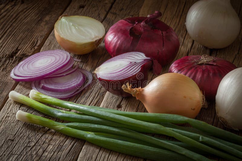 Assorted Farm Fresh Onions on a Wooden Table with Spring Onions Stock ...
