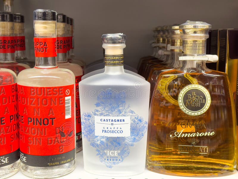 Assorted Grappa Bottles on Store Shelf with Various Flavor Labels ...