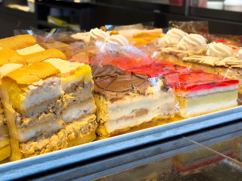 Assorted Layered Cakes in Display Case at Bakery Stock Photo - Image of ...