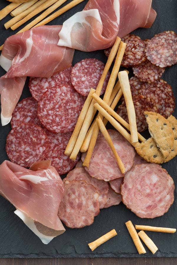 Assorted Meat Snacks and Pickles on a Blackboard, Top View Stock Photo ...