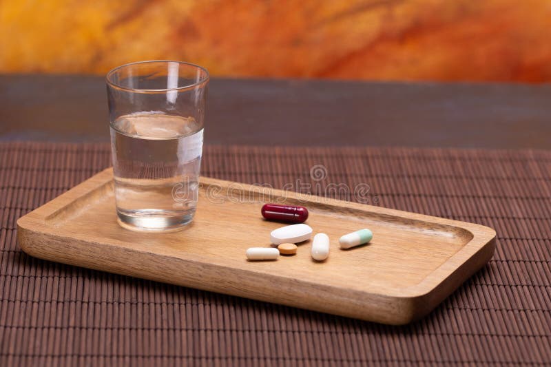 Assorted Pills and Glass of Water on Wooden Tray Stock Image - Image of ...