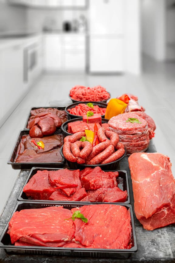 Assorted Raw Beef Meats on a Table with a Modern White Kitchen ...