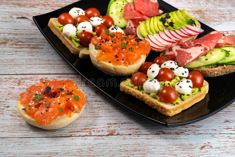 Assorted Sandwiches with Fish, Cheese, Meat and Vegetables on a Black ...