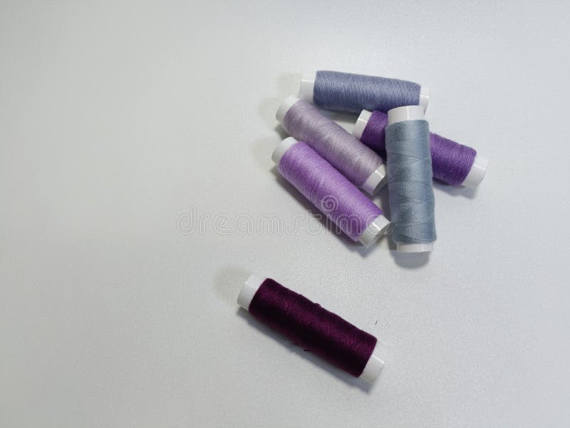 Top View of Assorted Purple and Gray Sewing Thread Spools on White ...