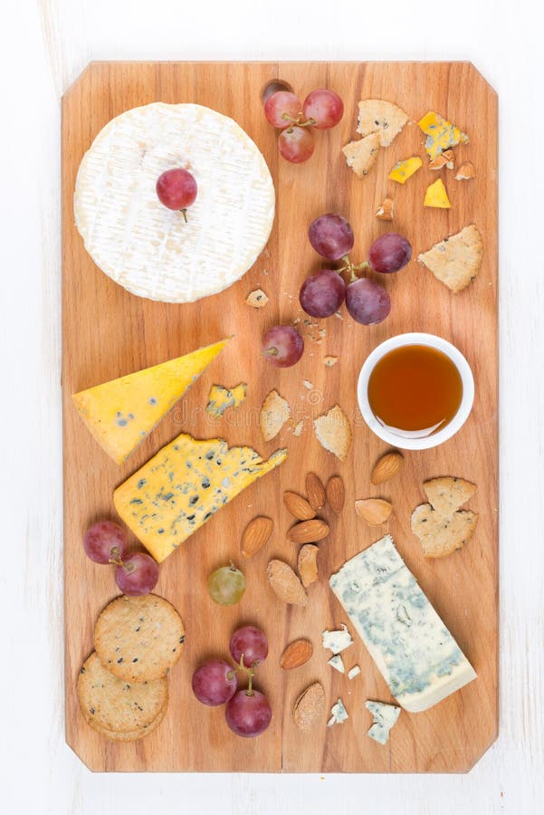 Assorted Soft Cheeses, Grapes, Nuts and Honey on a Wooden Board Stock ...
