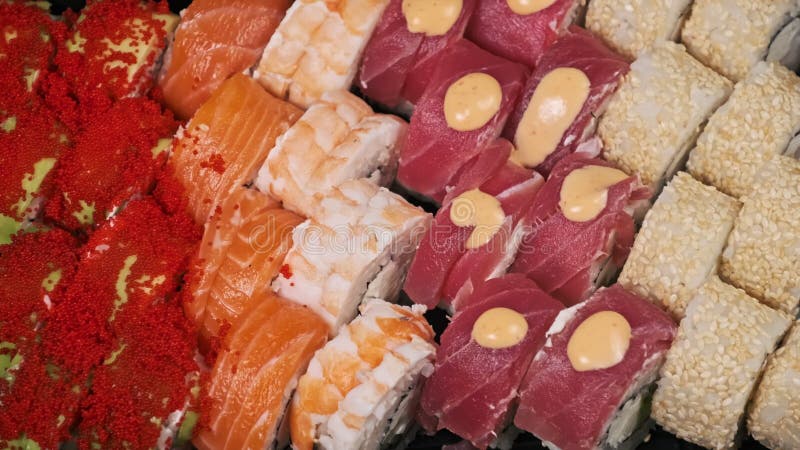 Assorted Sushi Rolls in a Rotating Delivery Box, Set Against a Black ...