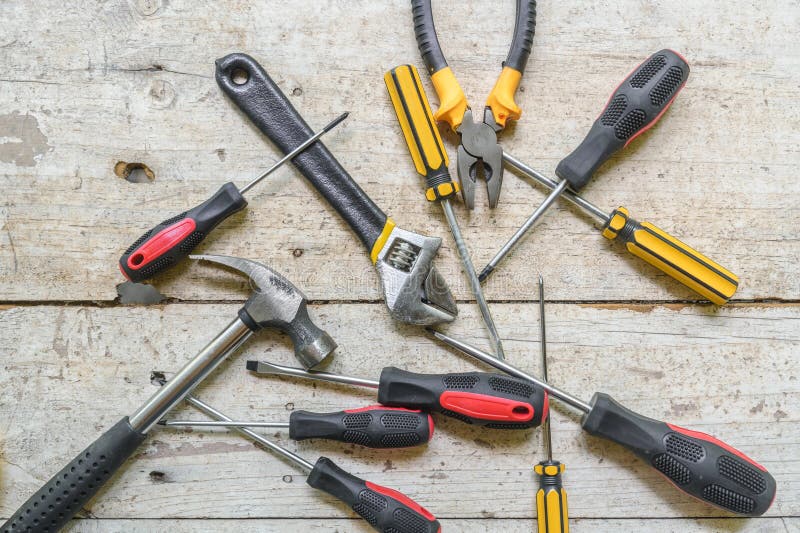 Assortment of Well-used Hand Tools Spread Out on a Worn Wooden Surface ...