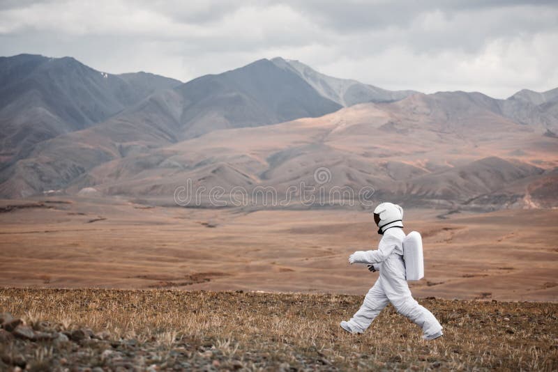 Astronaut Explores an Unknown Red Planet. Cloudy Sky and Mountains in ...