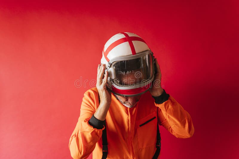 Astronaut with an Orange Space Suit Taking Off His Helmet on a Red ...