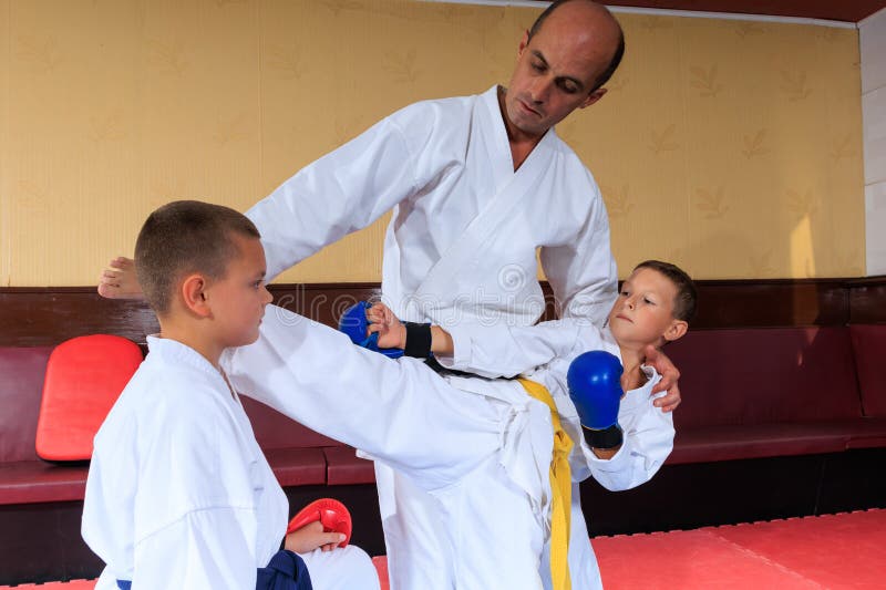 An Athlete in Blue Pads Performs a Kick on an Athlete in Red Pads with ...