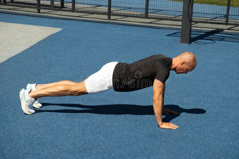 Athlete Does Push Ups on Sport Ground. Outdoors Training. Morning ...